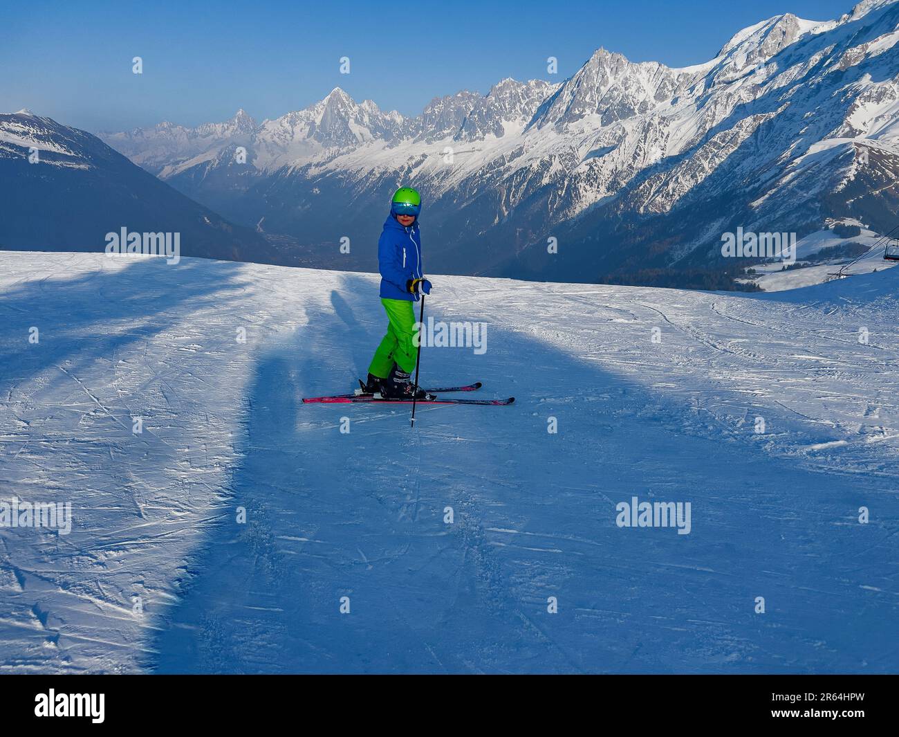 Boy stand on fresh ski track over French mountain summits Stock Photo ...