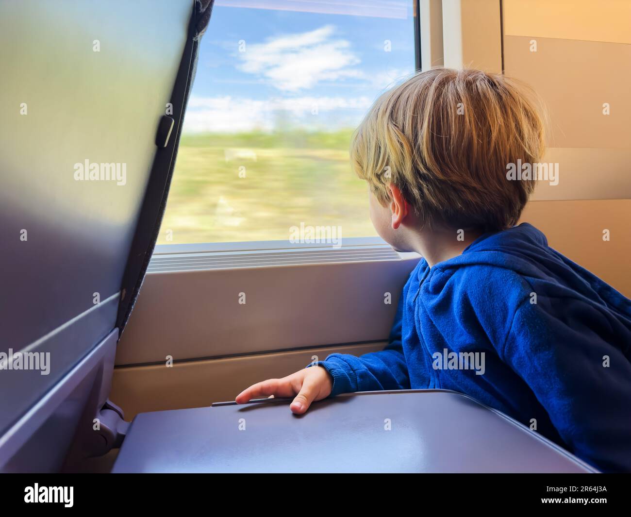Little boy sit and looking at the window inside high speed Stock Photo ...