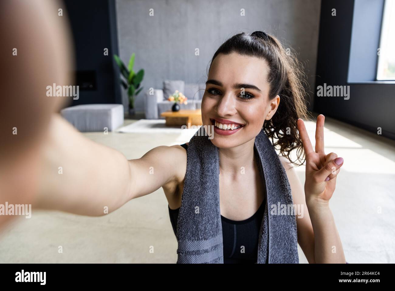 Young woman doing self portrait on yoga mat. Home vacation indoors ...