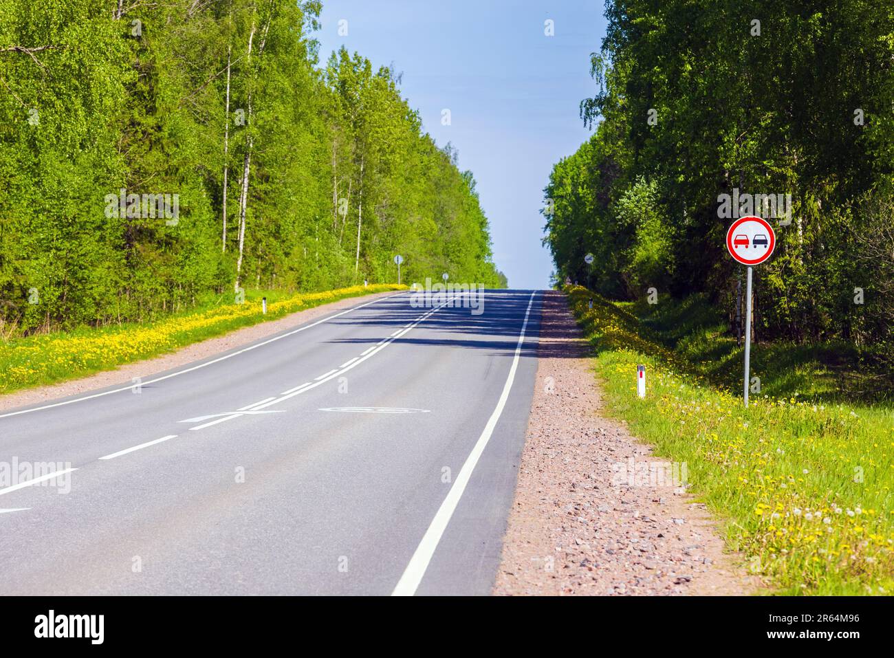 No overtaking. Road sign on metal pole mounted on a highway roadside ...