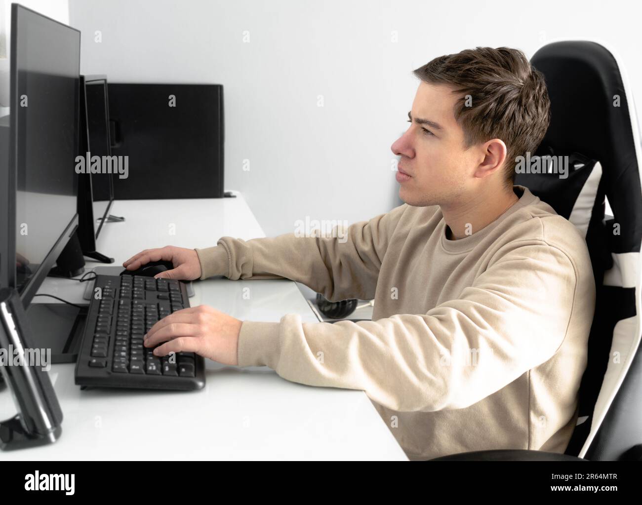 Teenager studies using the computer at the desk in his room Stock Photo ...