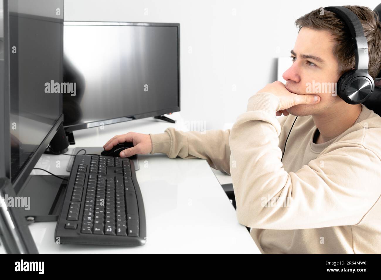 Young student man with headphones using a computer with a gesture of ...