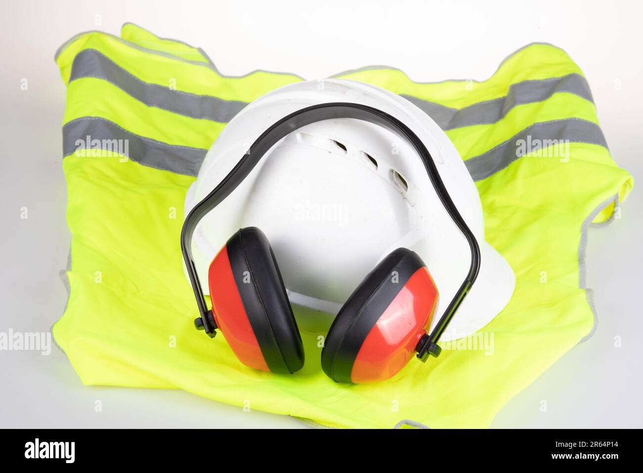 white helmet ear muffs placed on yellow reflective safety jacket on ...