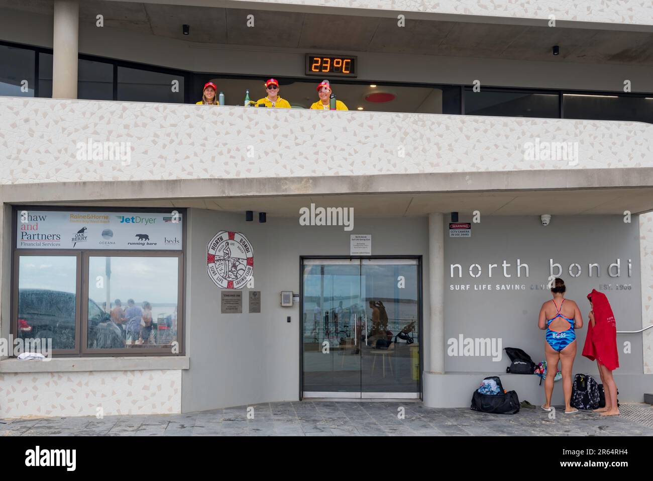 Three young women surf life savers watch over the beach from the ...