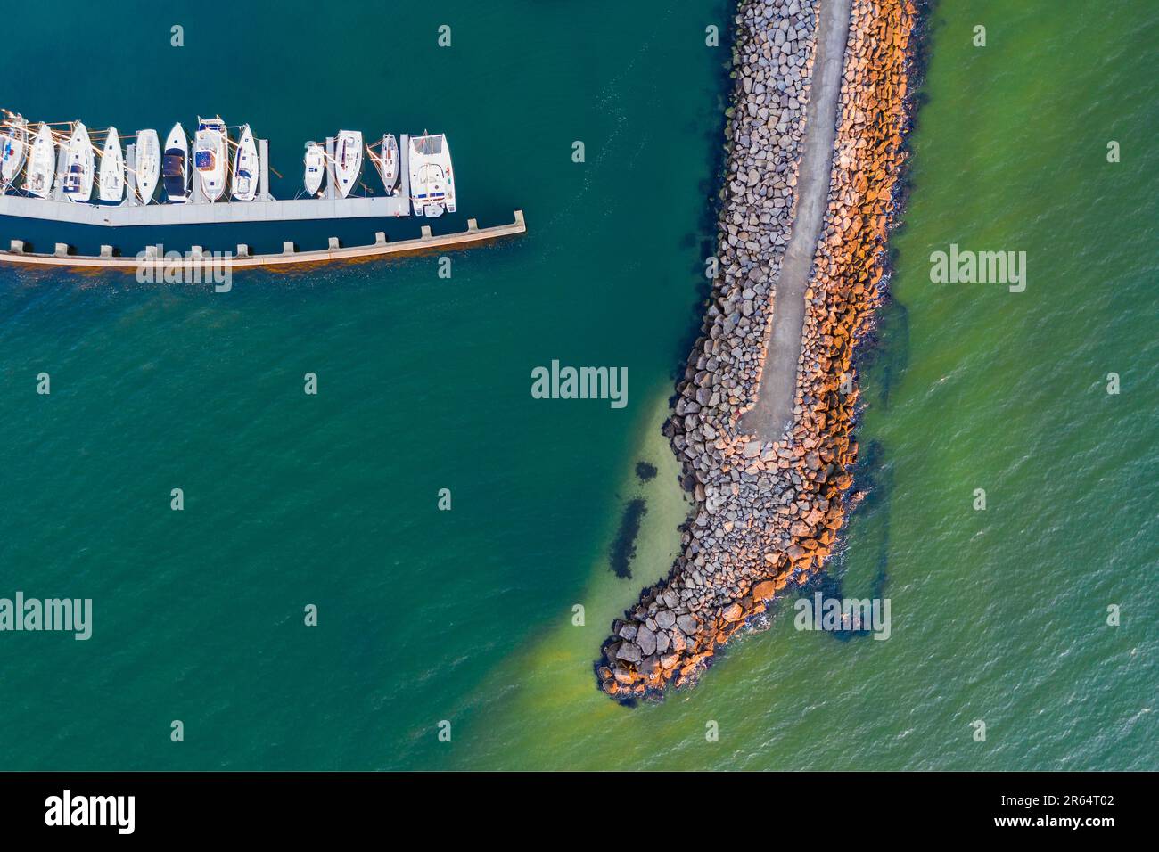 Aerial view of boats at a marina inside a rocky breakwater at ...