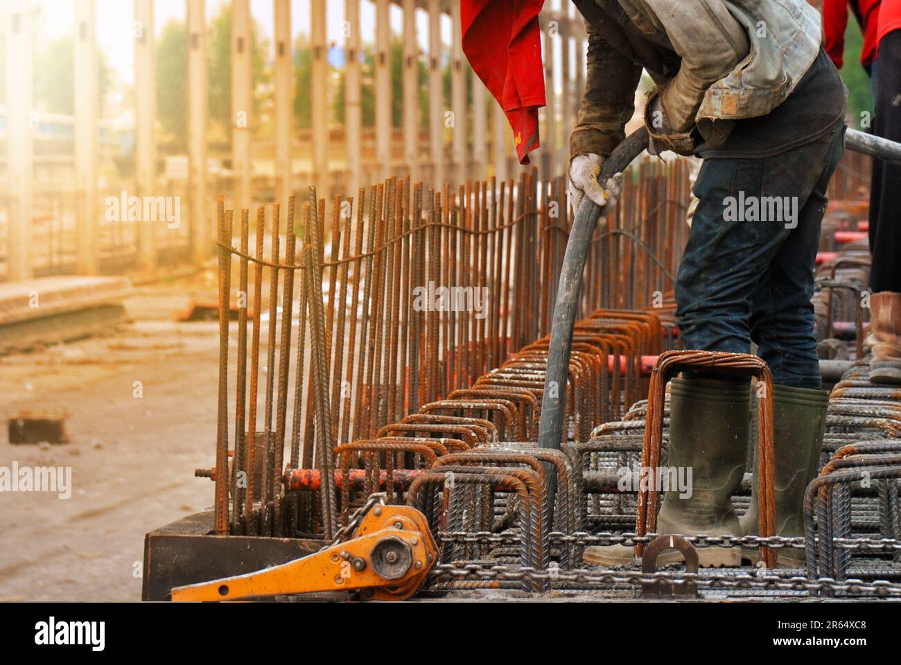 Construction worker pouring cement or concrete with pump tube at ...