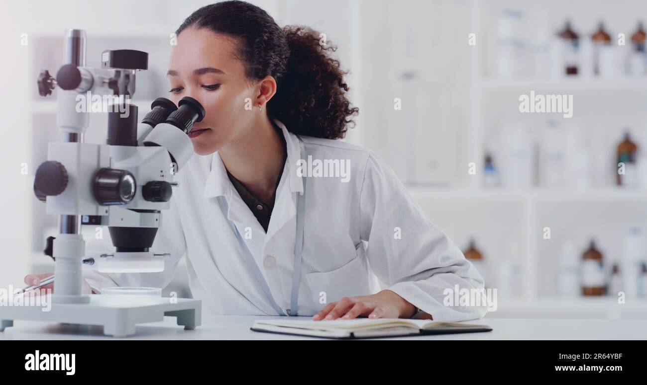 Science, notebook and microscope with woman in laboratory for expert research, medical and ...