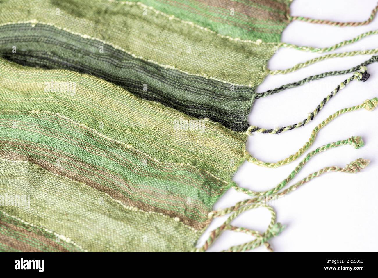 Green fringed scarf fabric on white background Stock Photo - Alamy