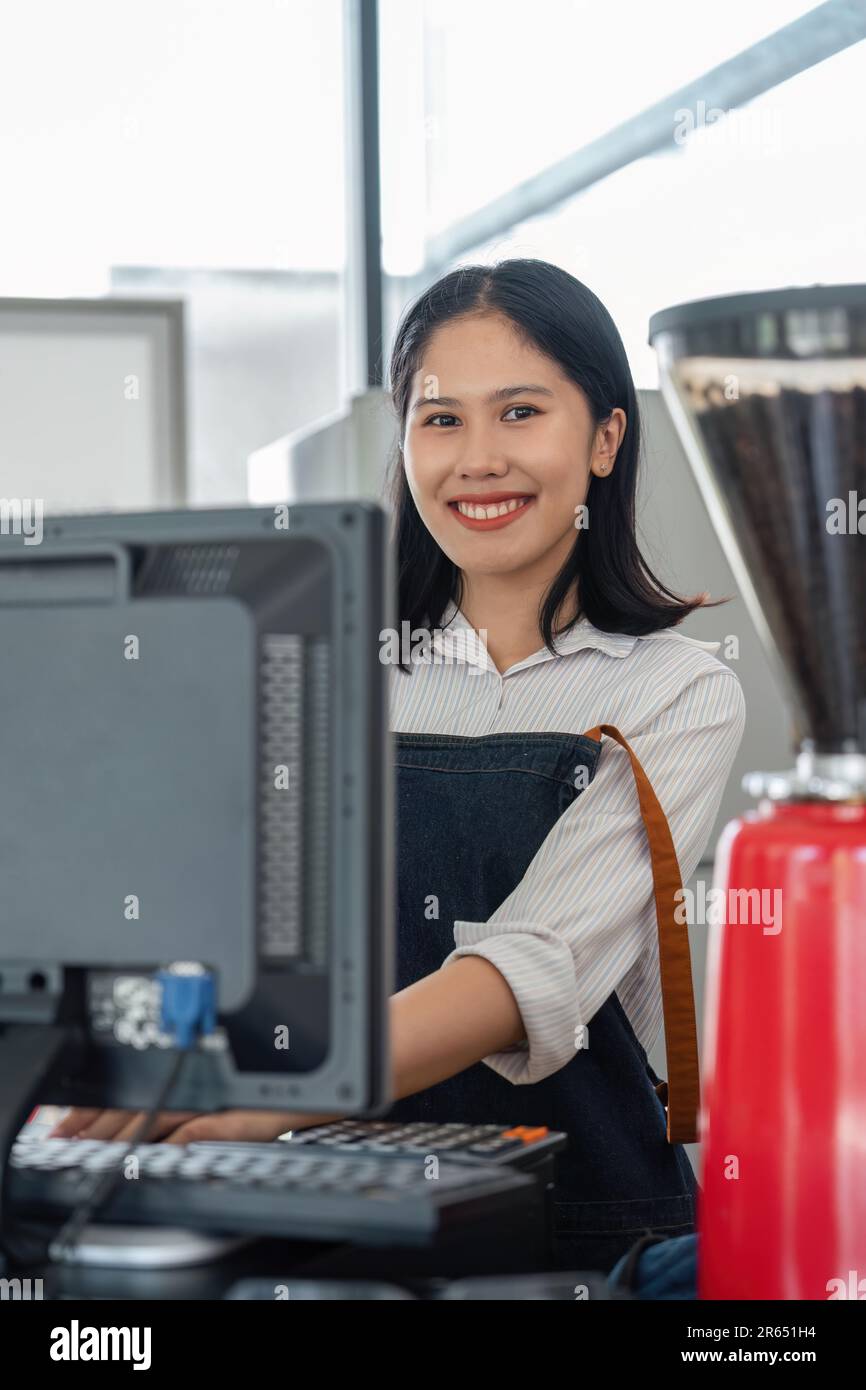 Cheerful shop assistant using digital device for payment Stock Photo ...