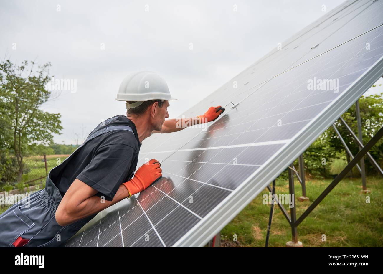 Man engineer installing solar modules. Male worker in safety helmet and ...
