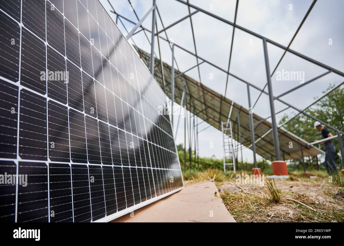 Set of solar panels near not finished solar energy system in field ...