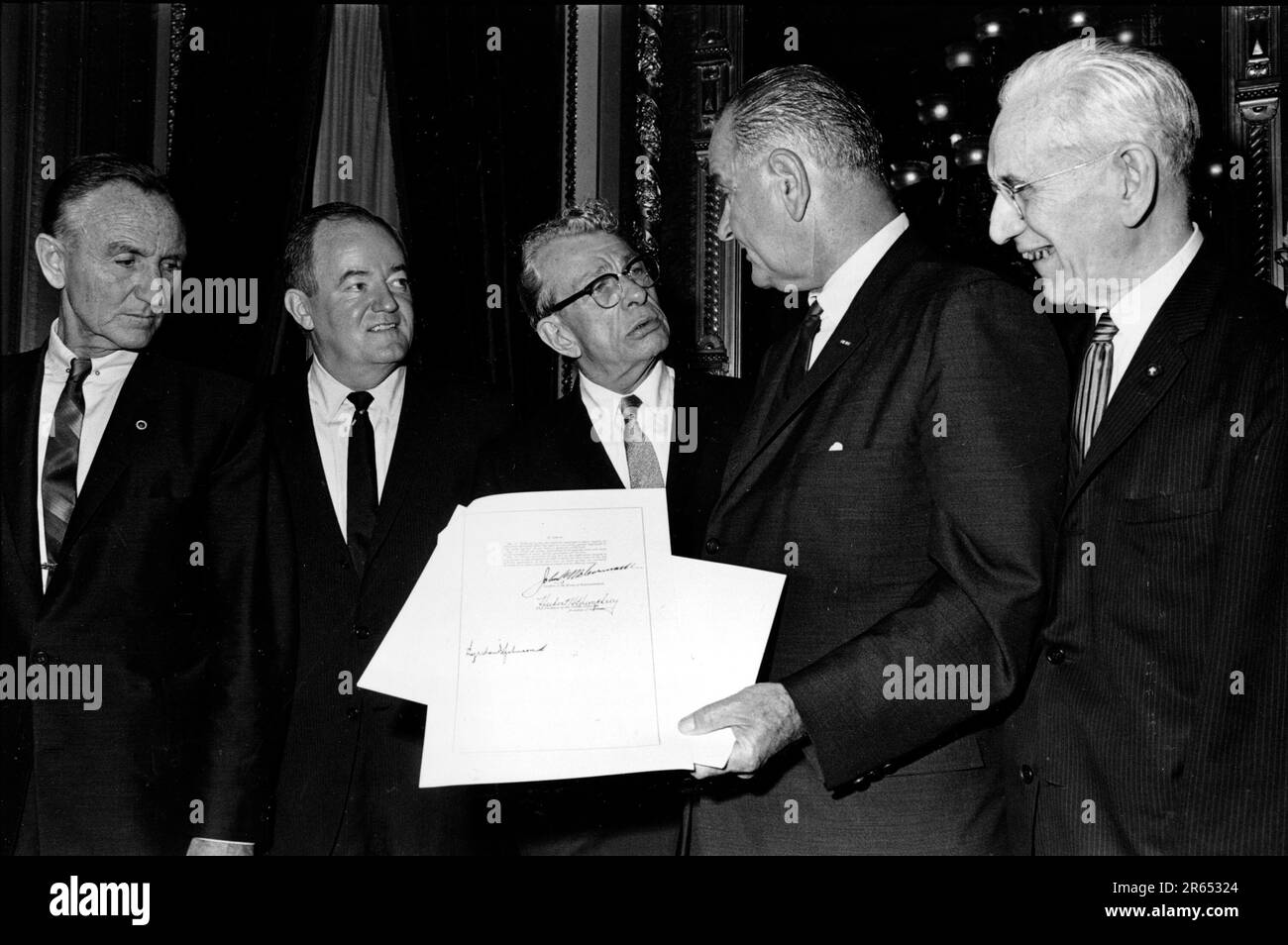 FILE - President Lyndon B. Johnson holds the signed document of the ...