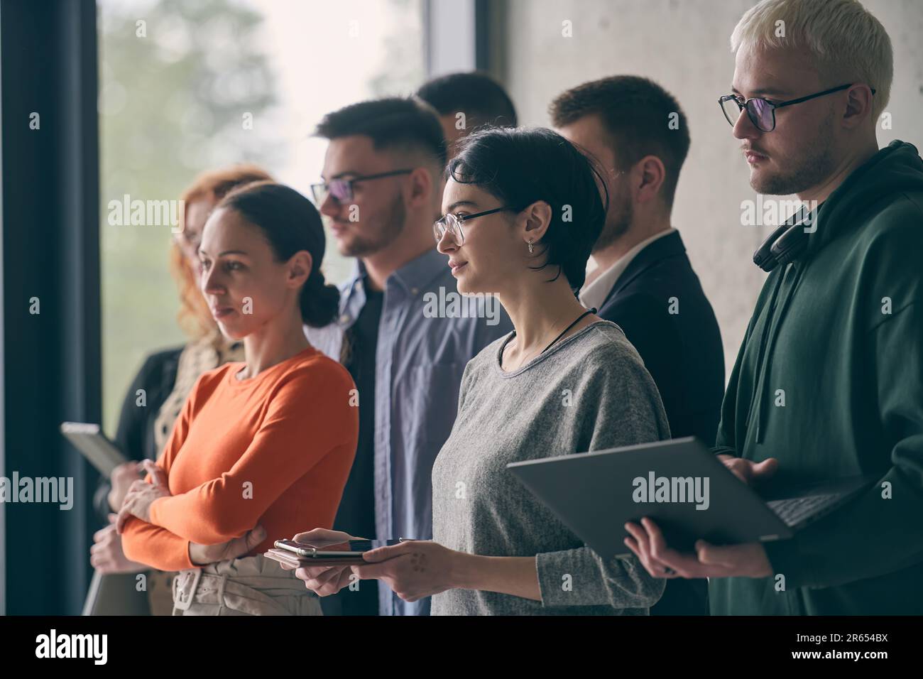 A diverse group of entrepreneurs in a modern office symbolizes a strong team of businessmen ...