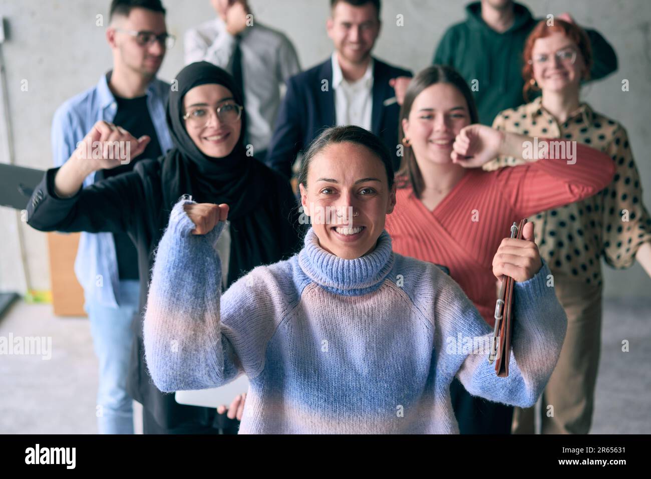 A diverse group of successful businessmen raises their hands in the air ...