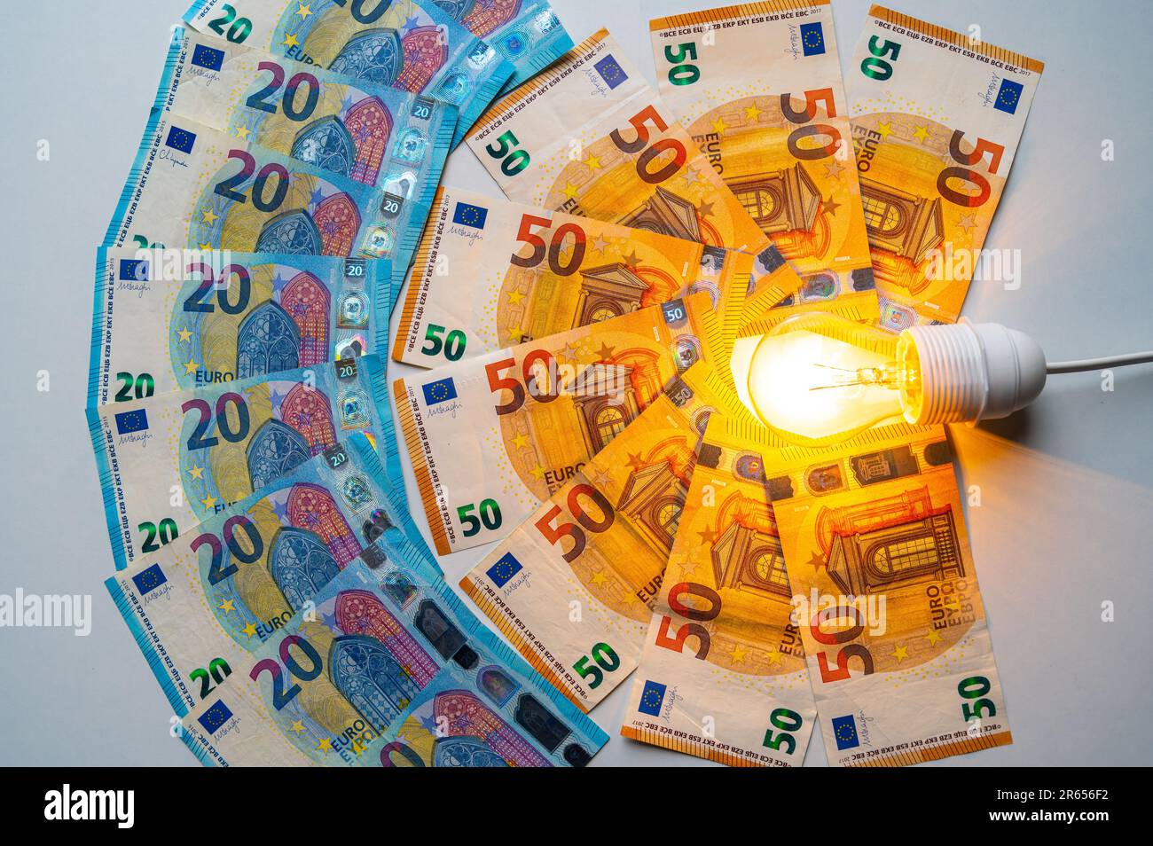 Light bulb turned on, with Euro banknotes around. Increase in ...