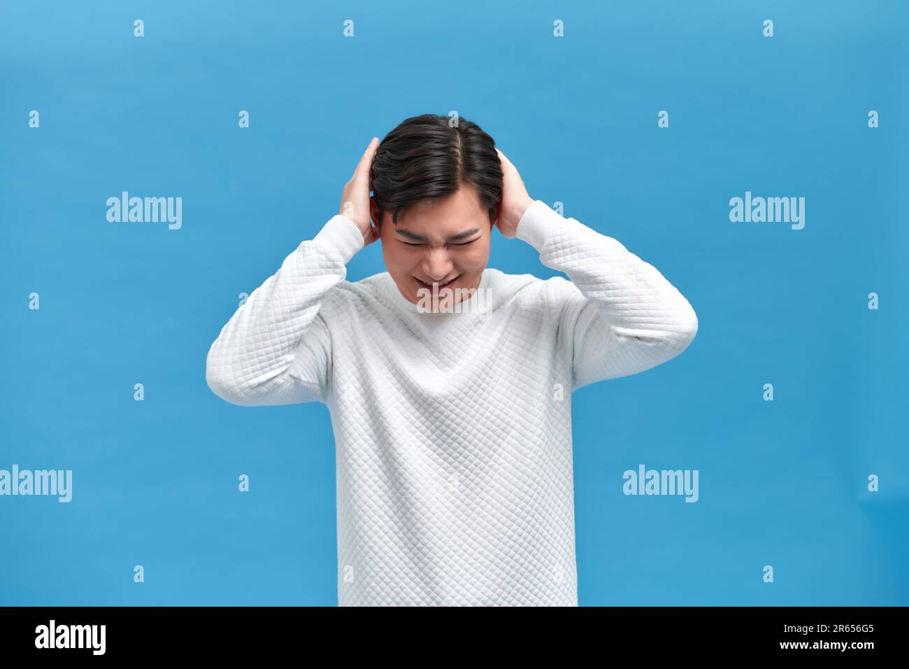 Portrait of handsome asian man dizzy while holding head with both hands ...