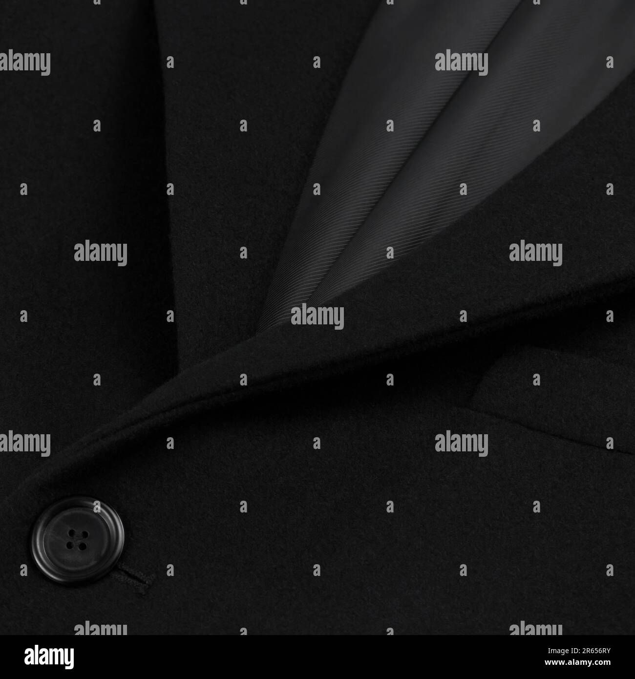 Details of a black wool coat: collar, button and chest pocket close up ...