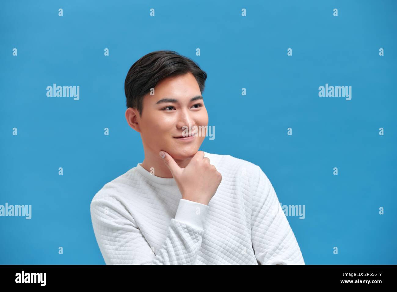 Smart handsome smiling young Asian man thinking with hand on chin Stock ...