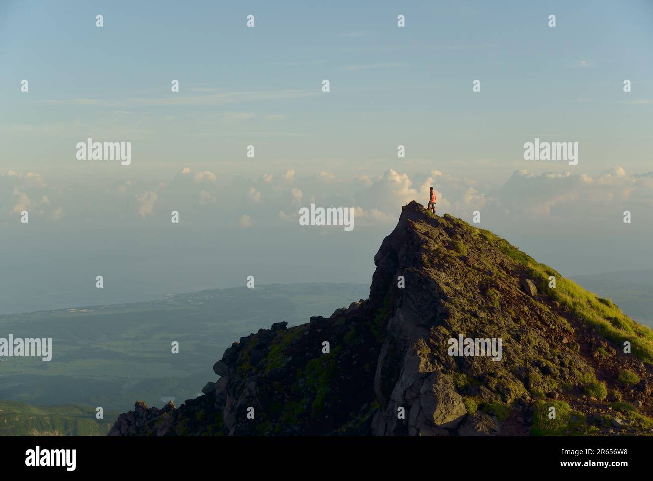 Climber standing on the summit Stock Photo - Alamy