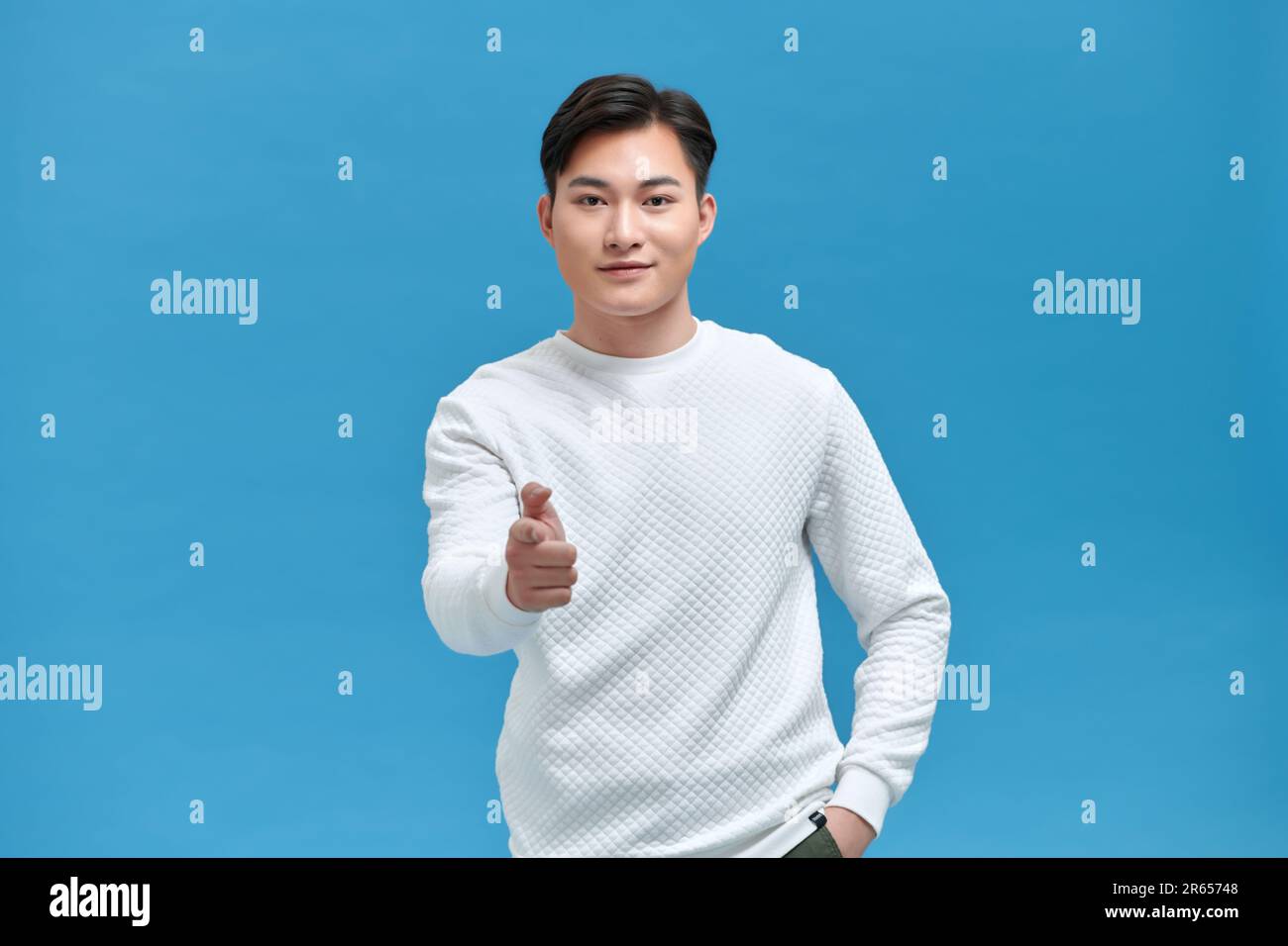 A friendly asian man points to the camera while smiling. Endorsing ...