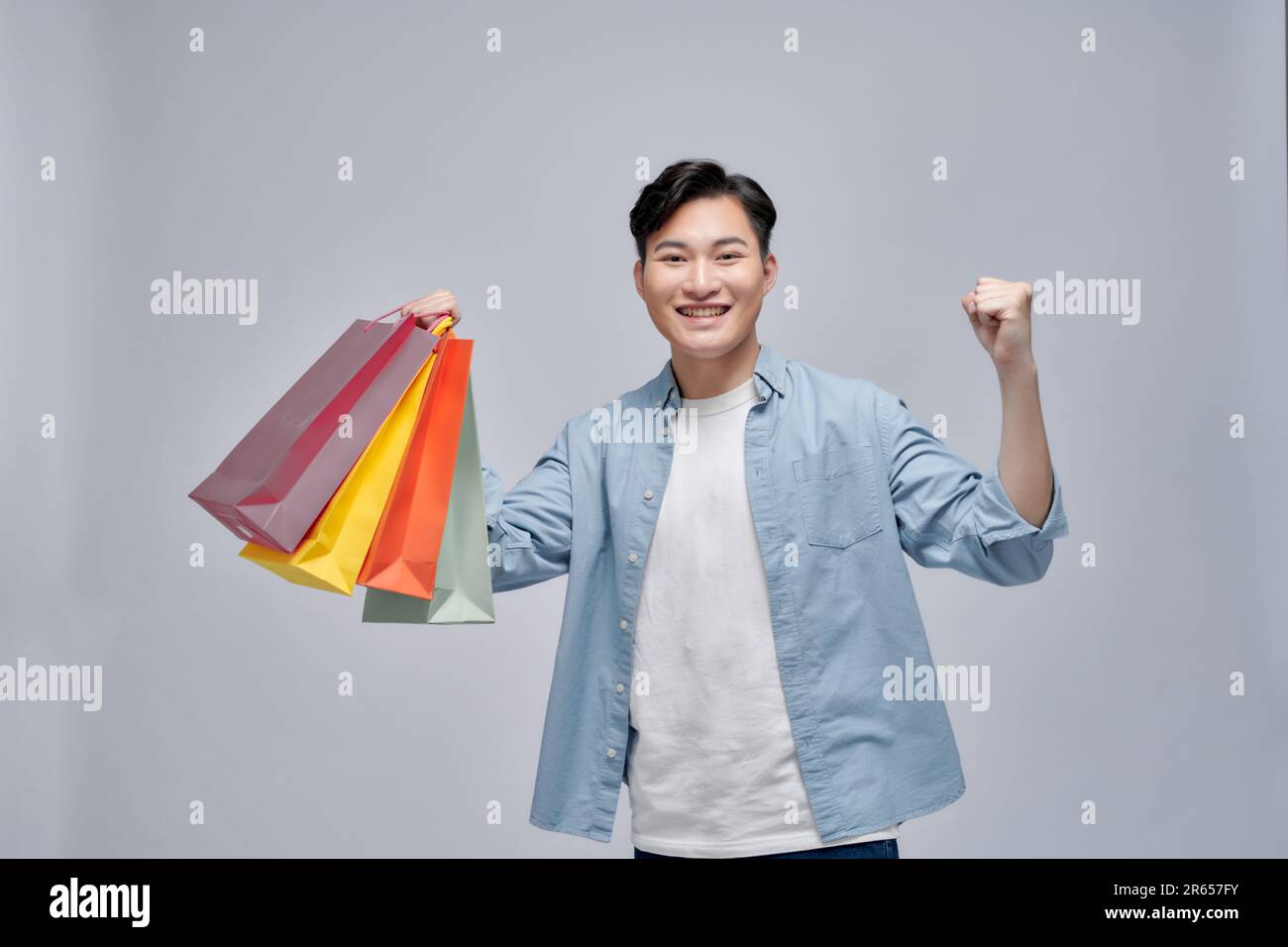 asian man smiling and holding the shopping bags on white isolated ...