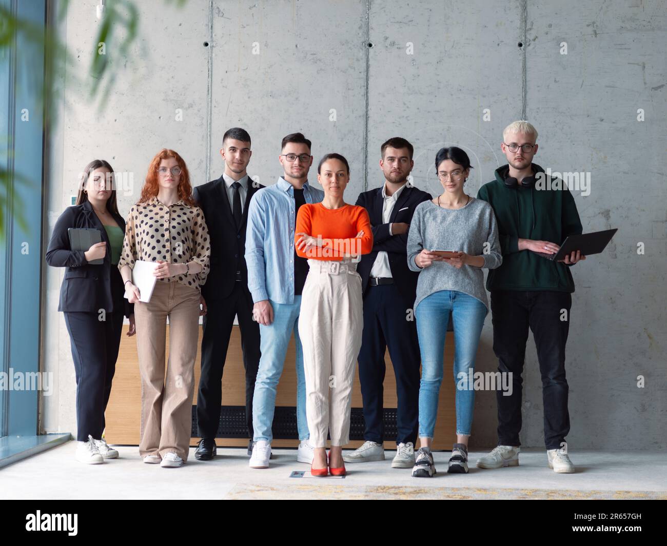 A diverse group of successful businessmen raises their hands in the air ...