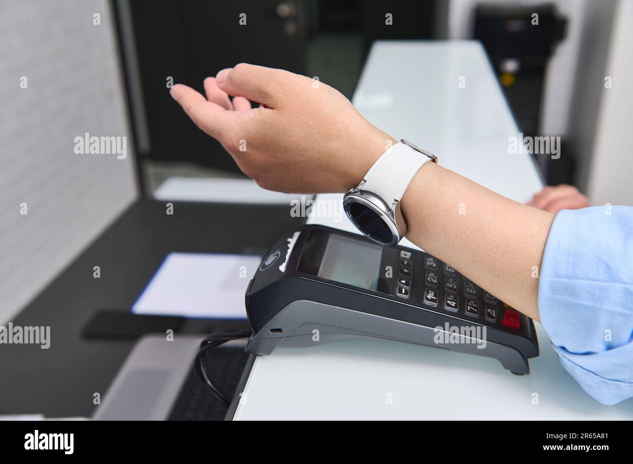 Close-up woman paying bill by smart watch with NFC technology. Customer ...