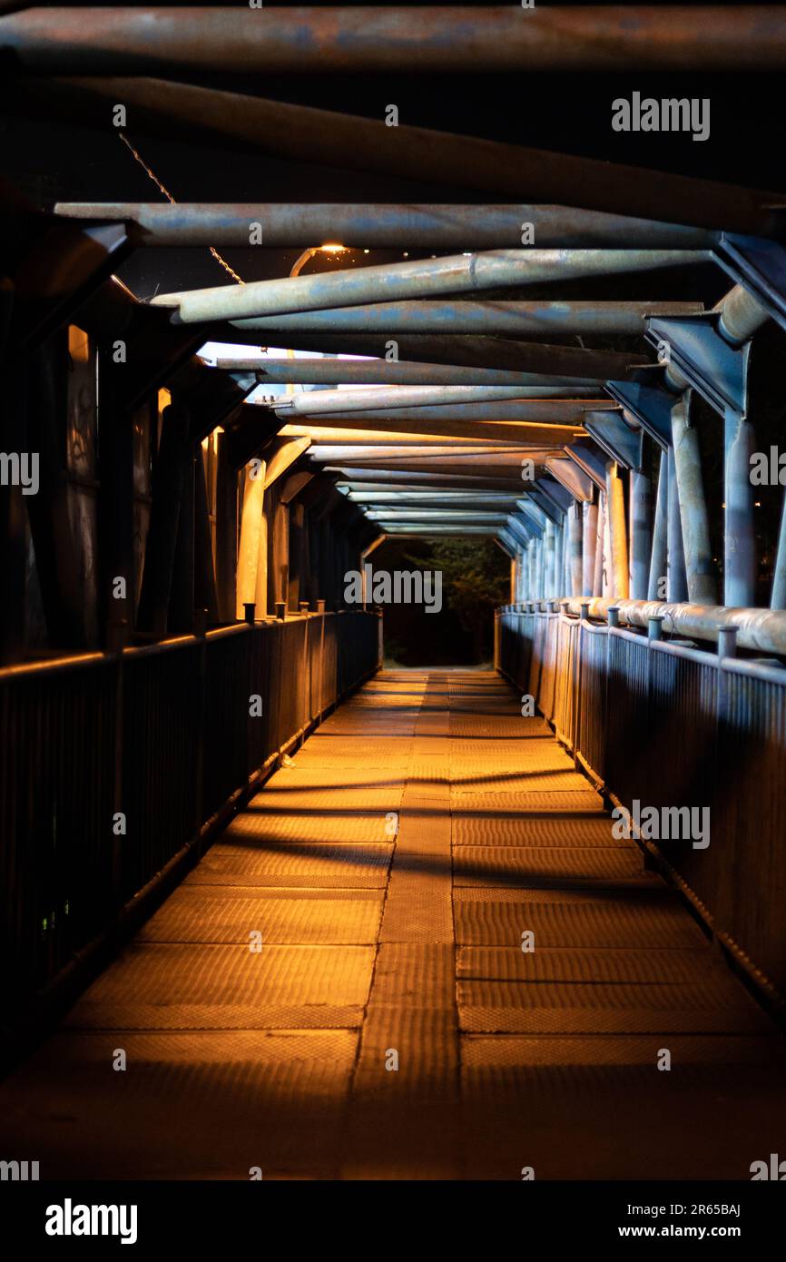 A night-time view of an illuminated pathway in a dimly lit environment ...