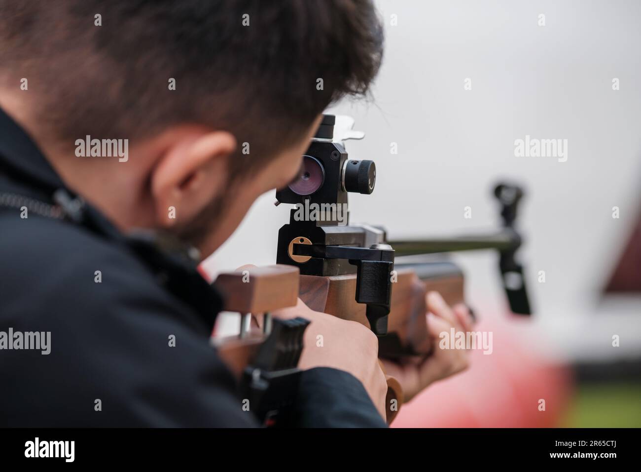 Back view of crop unrecognizable male professional precision shooter in ...