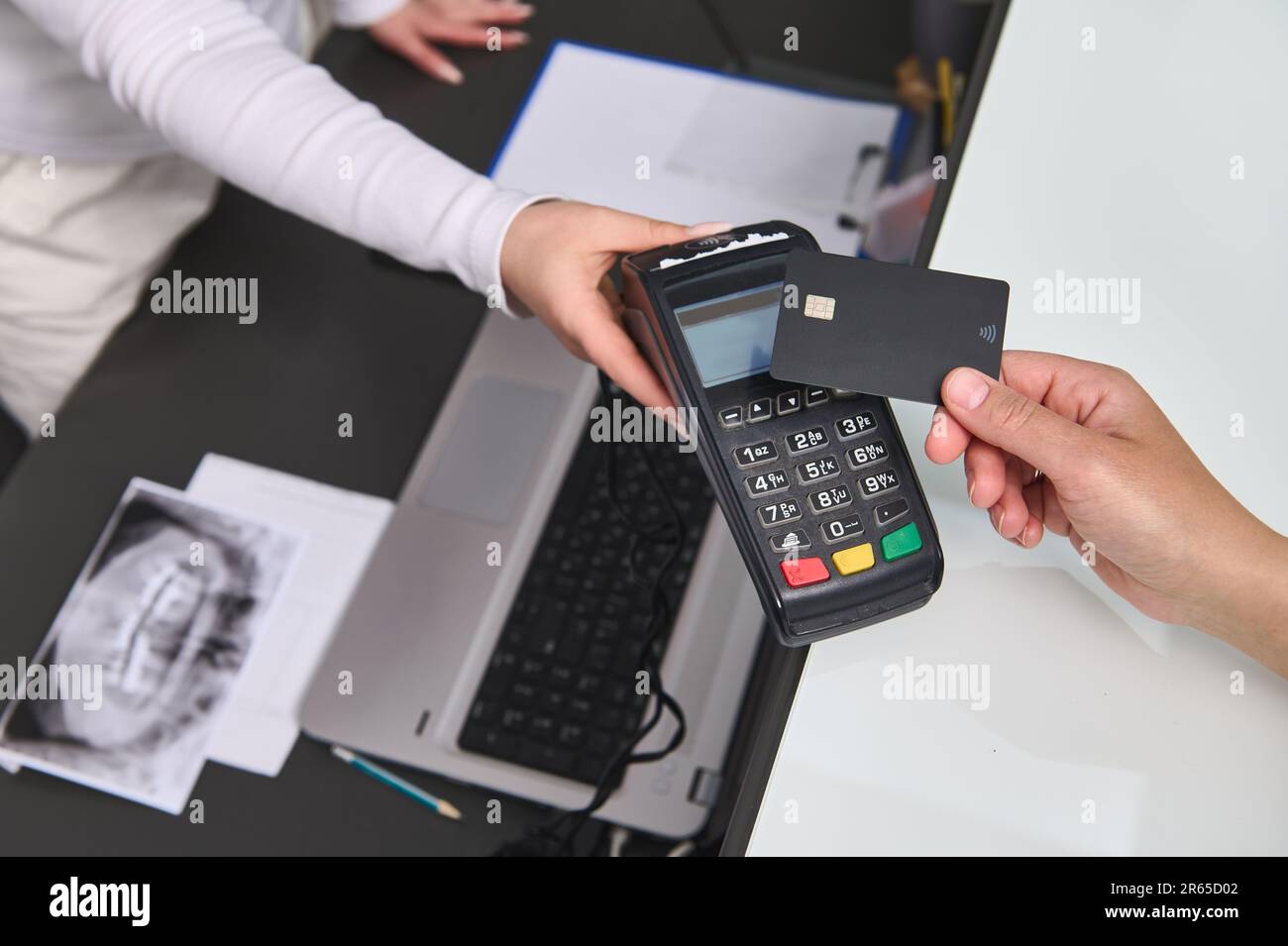 Top view customer hand holds black mockup credit card above a POS ...