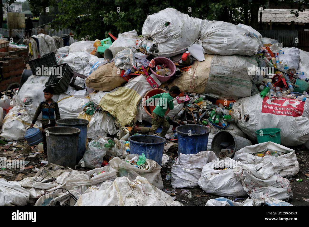 Srinagar, India. 05th June, 2023. Children walk past plastic waste near ...