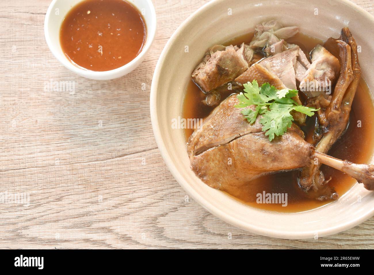 boiled duck meat in black soybean soup in bowl dipping spicy chili ...