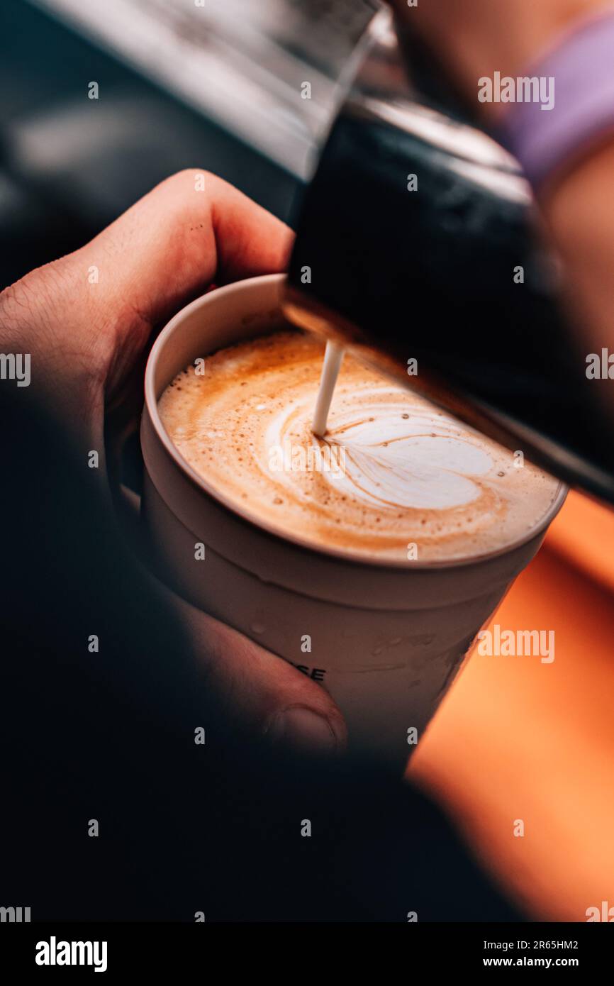 A barista making a latte at a cafe Stock Photo - Alamy