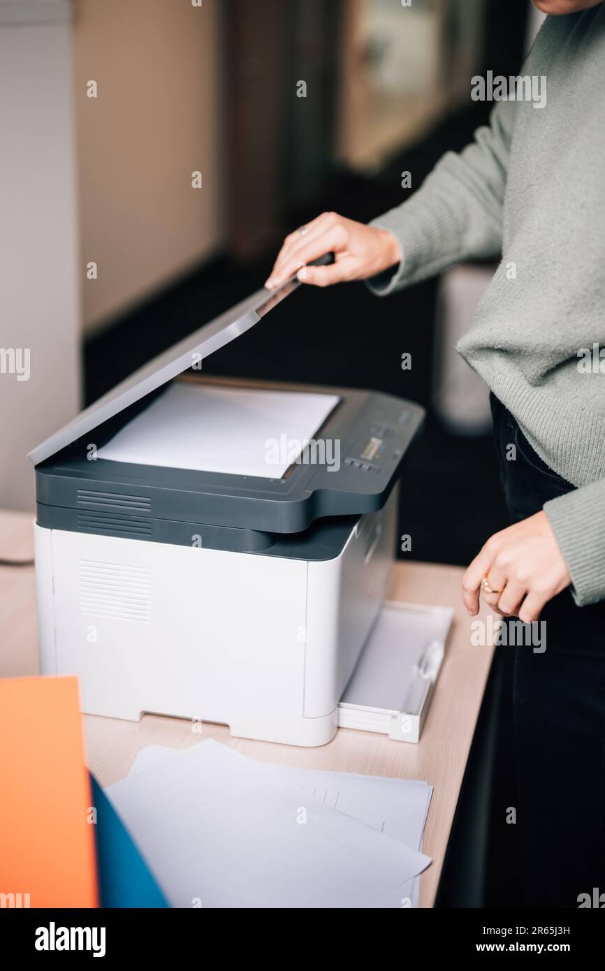 A female office worker using the printer at the office Stock Photo - Alamy