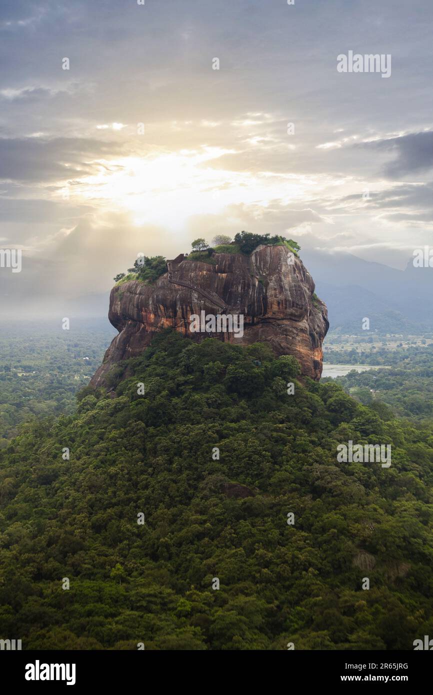 A scenic landscape featuring a grassy hilltop dotted with trees and ...