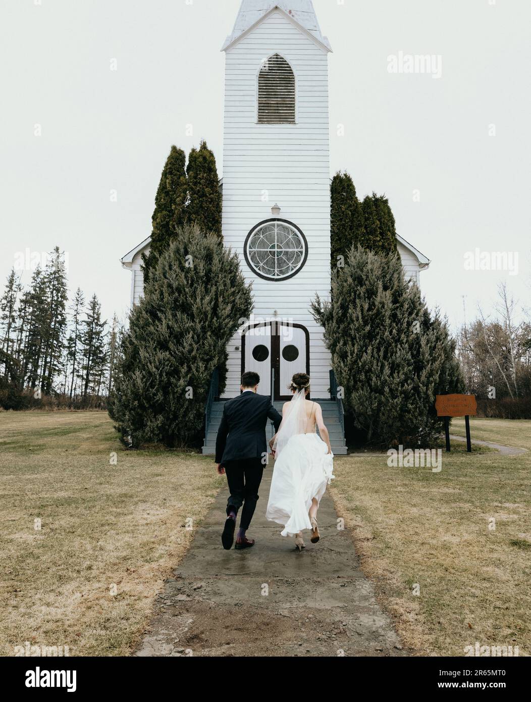 The newly weds running in front of old church holding hands Stock Photo ...