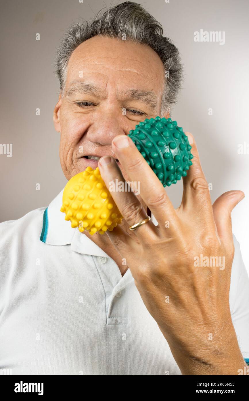 Mature man holding and squeezing massage therapy spike balls Stock ...