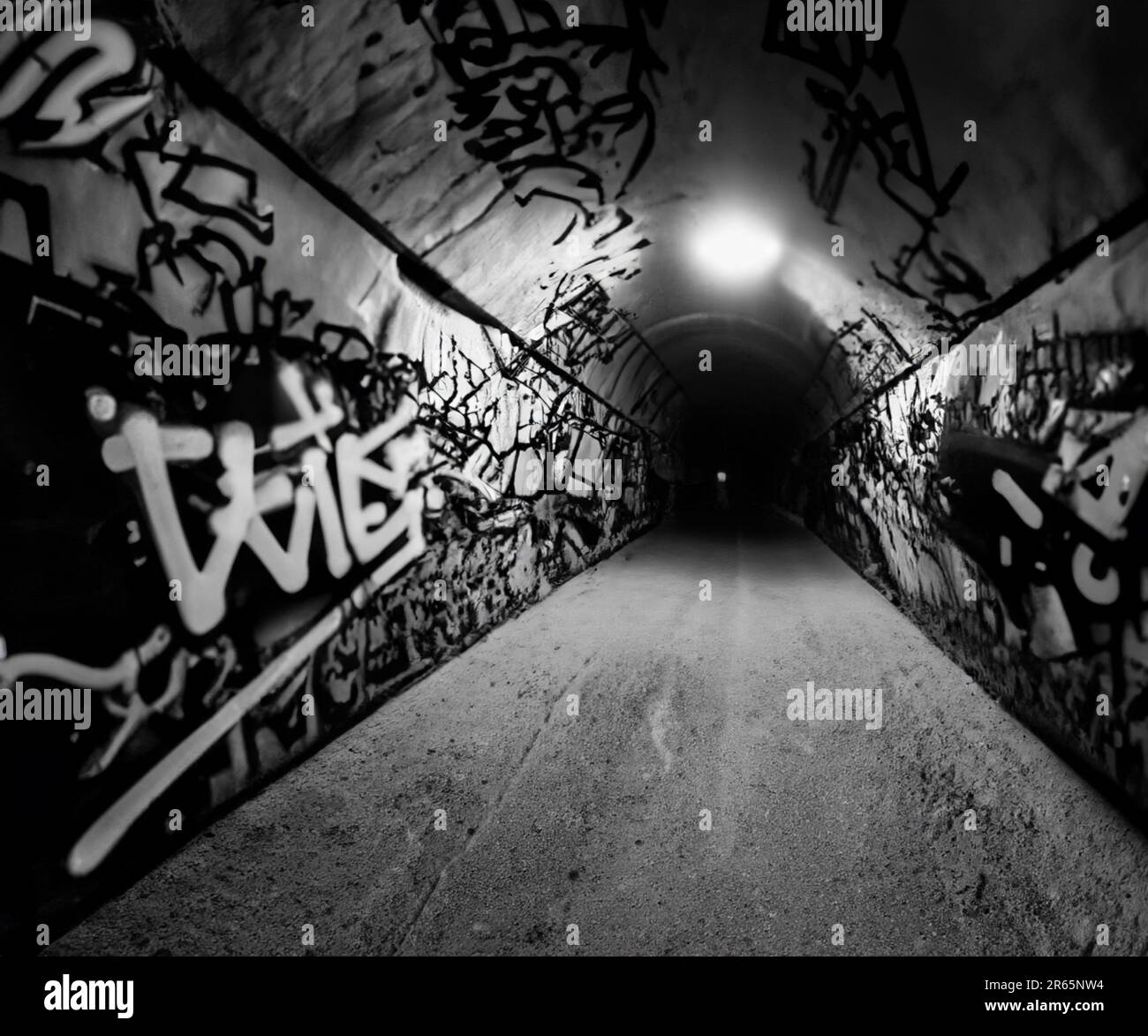 An urban tunnel featuring multicolored graffiti art adorning the walls ...