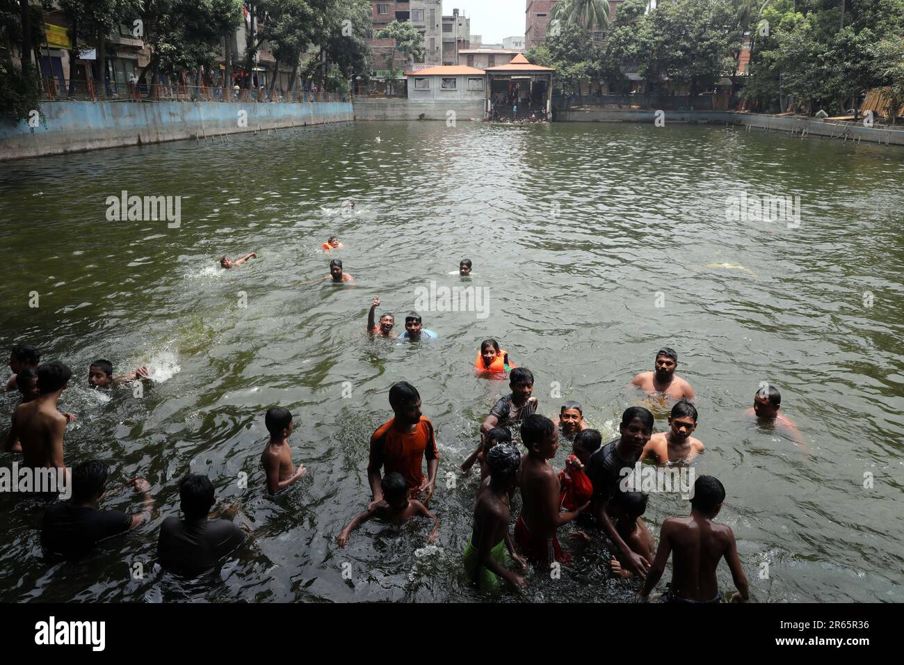 DHAKA, BANGLADESH - JUNE 2: People bathe at a pond in Old Dhaka on June 2, 2023 in Dhaka ...