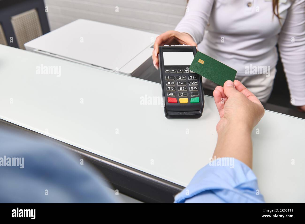 Female administrator receptionist with credit card reader machine at ...