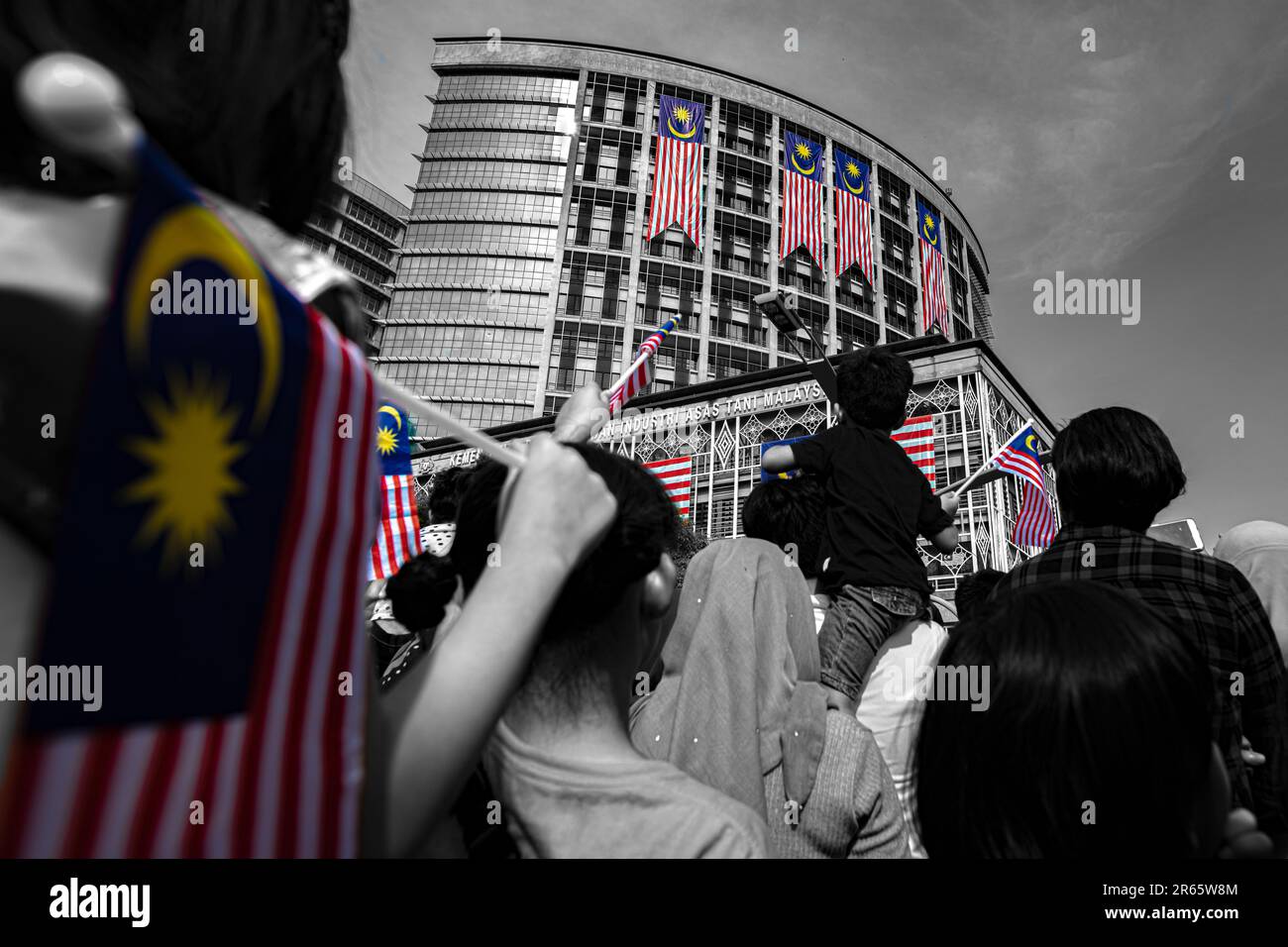A diverse group of people holding national flags in a circle formation ...