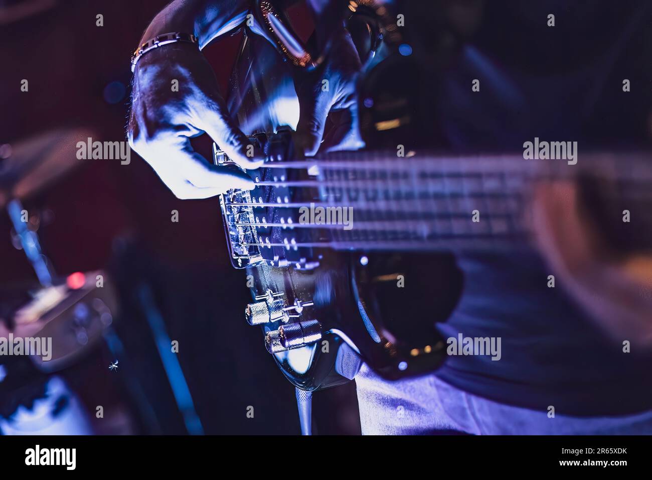 A close-up photo capturing the skillful hand of a bassist playing the ...