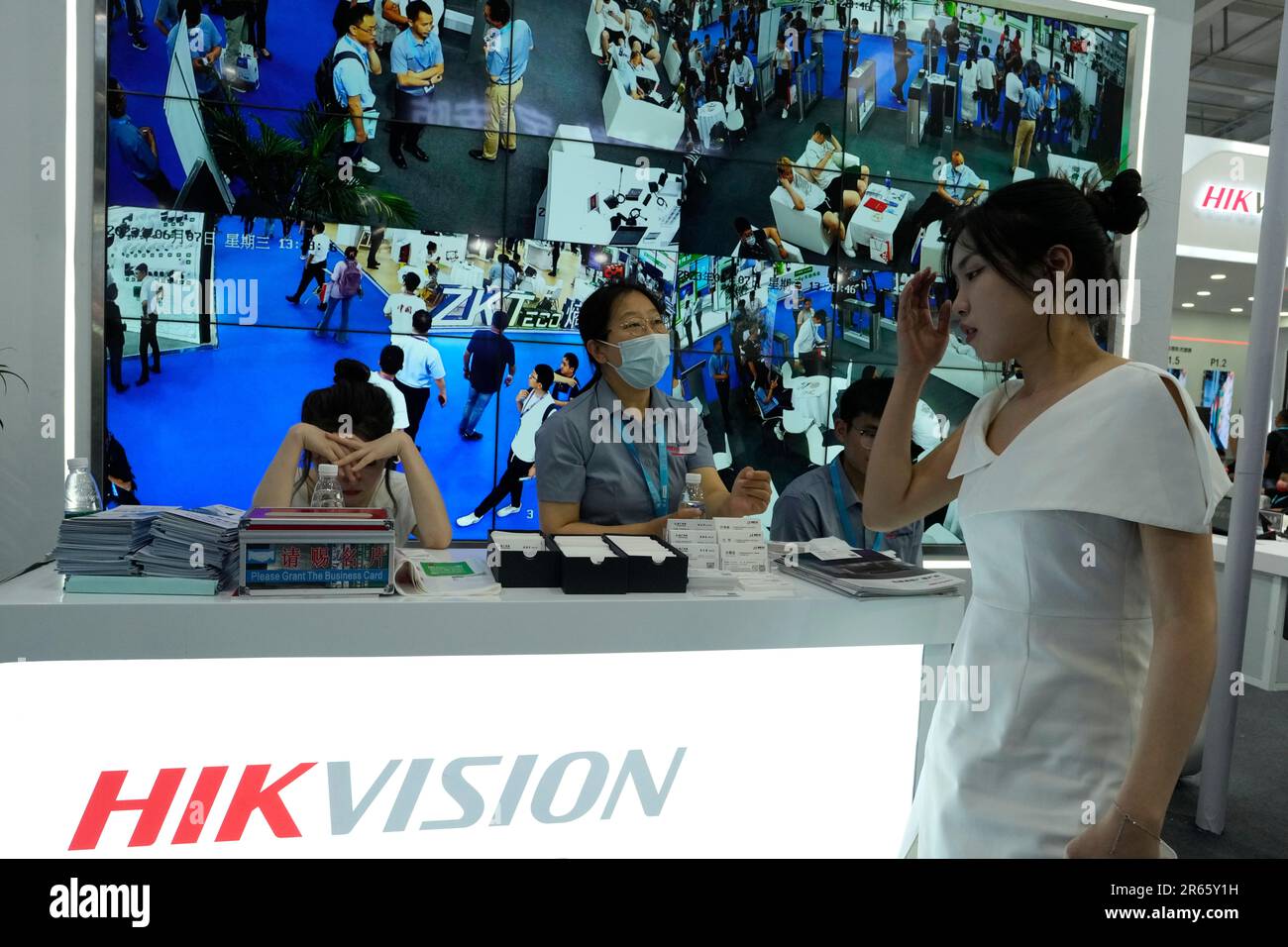 Staffers wait for visitors under display of CCTV images at the ...