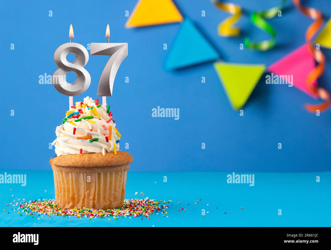 Birthday cake with candle number 87 - Blue background Stock Photo - Alamy