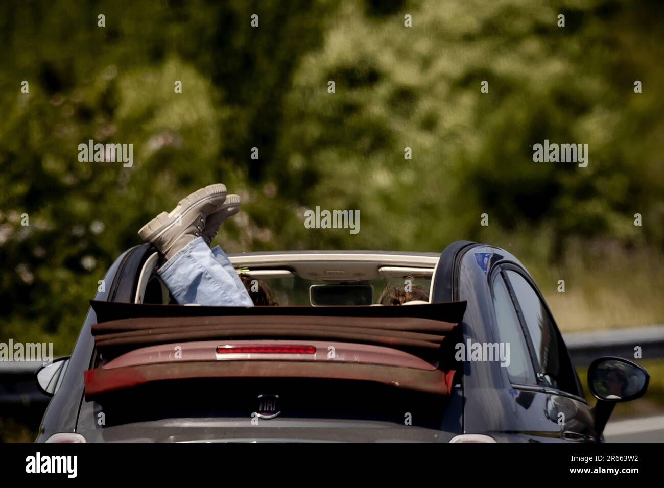UTRECHT - Two shoes stick out of a convertible with an open roof. The ...