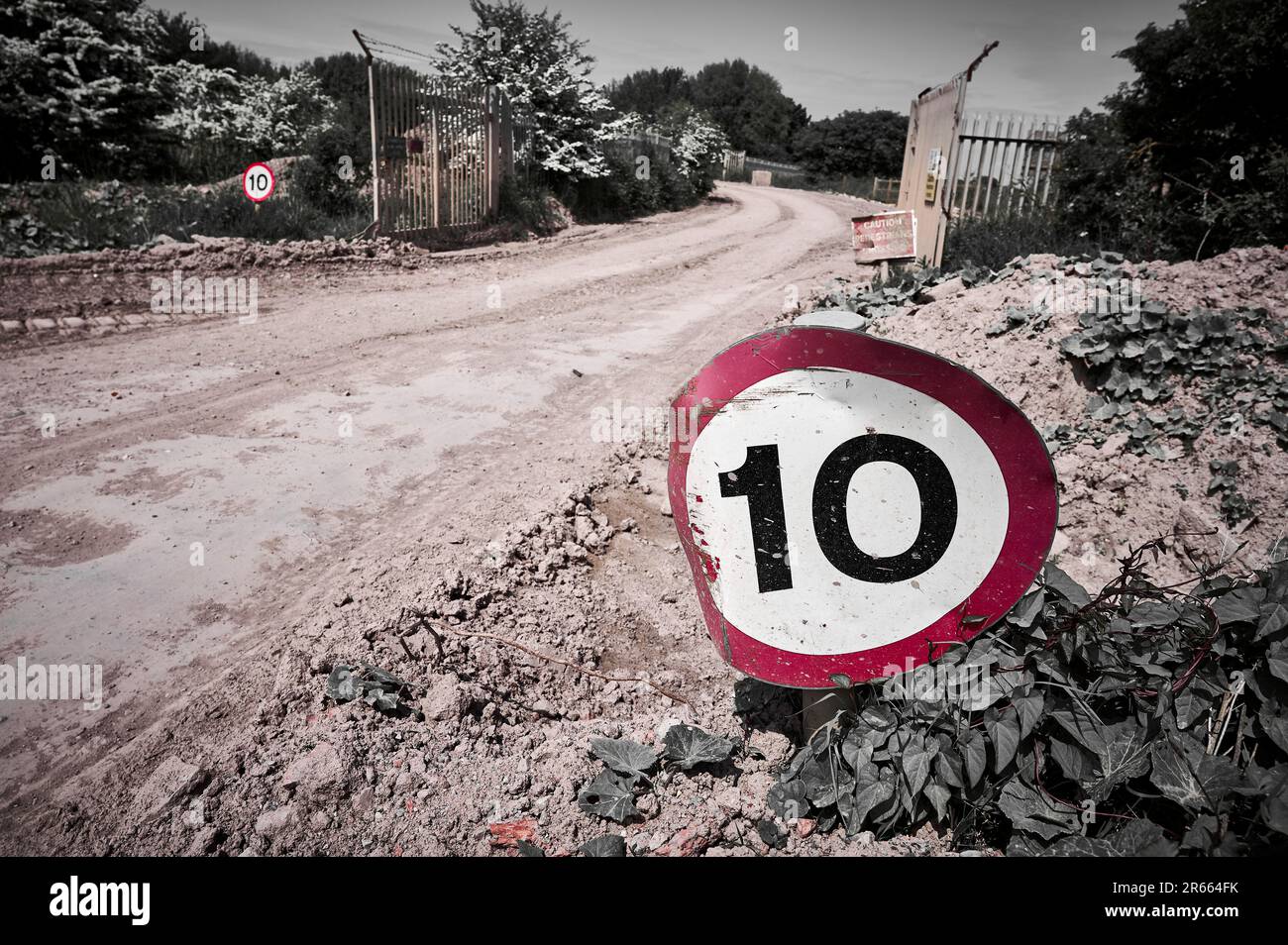 Speed limit sign on mud covered road on industrial site Stock Photo - Alamy