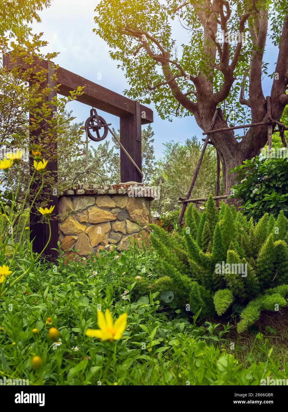 Beautiful artesian well made by stones and wheel pulley with metal ...