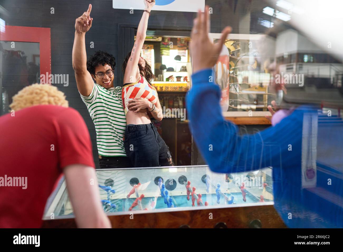 Happy young couple celebrating foosball victory in game room Stock ...