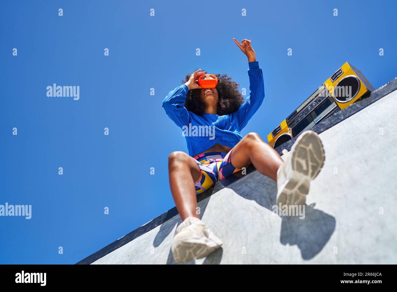 Young woman with boom box using view finder against blue sky Stock ...