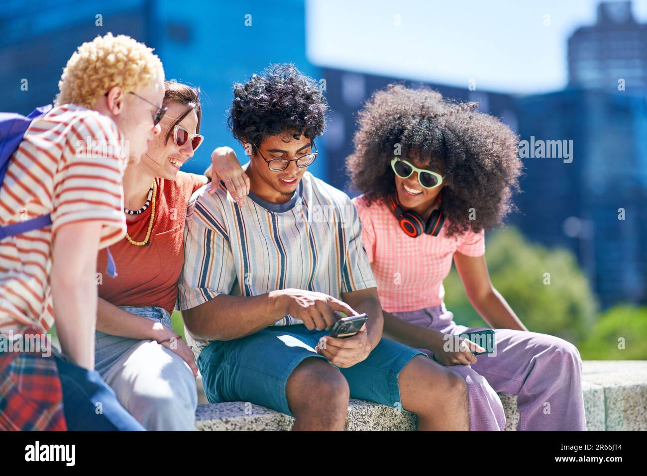 Young friends using smart phones in sunny city Stock Photo - Alamy